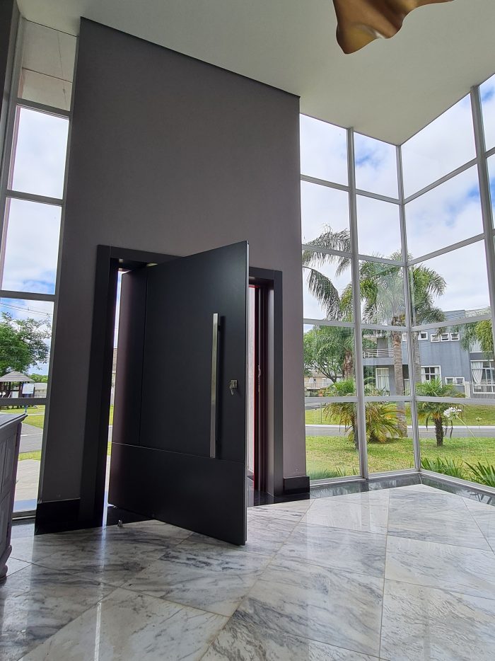 Porta pivotante em ACM com duas cores. Lado externo vermelho fosco e ...